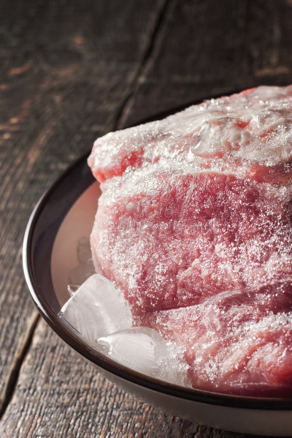 Frozen Pork on the Plate with Ice on the Wooden Table Stock Image ...