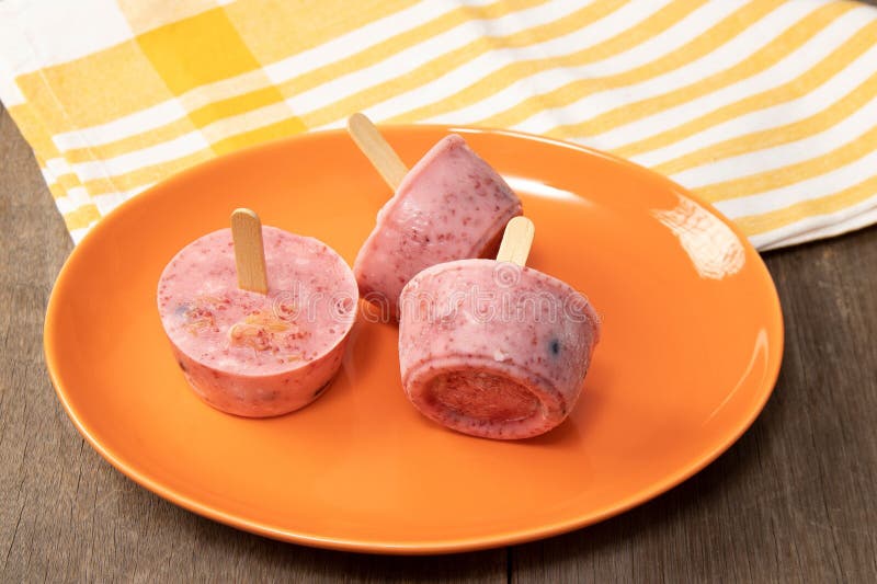 Frozen Raspberry Popsicles on an Orange Plate Presented on a Tabletop Stock Image - Image of ...