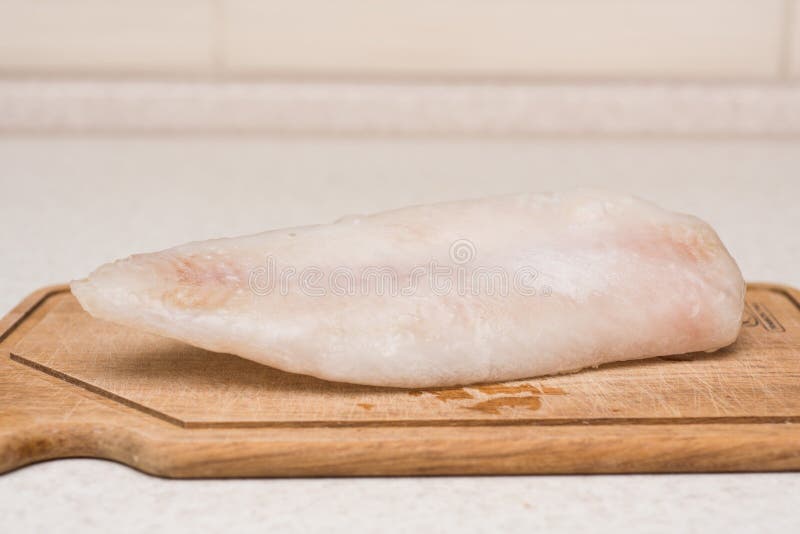 Frozen and Thawed Fish Fillet on the Cutting Board Stock Photo - Image ...