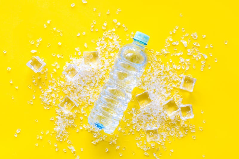 Frozen Water In Ice Cubes And Bottle On Yellow Bar Table Top View Stock ...