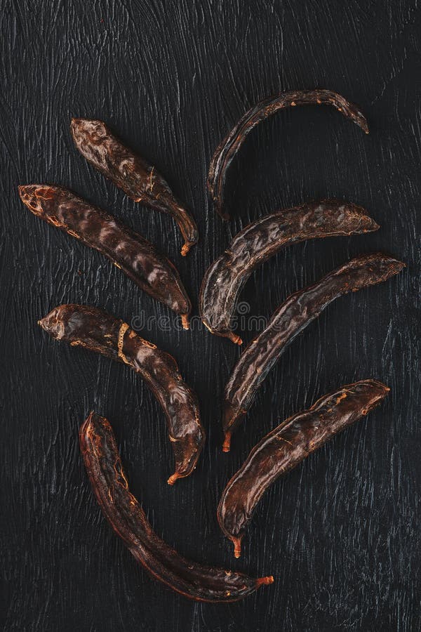 Fruit and Carob Tree Seeds and Cinnamon Sticks Shot Close-up on a White ...