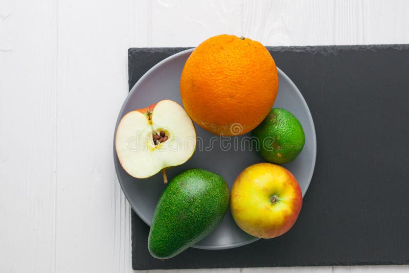 Fruits. Orange, Lime, Apple, Avocado on Black Stone Stock Photo - Image ...