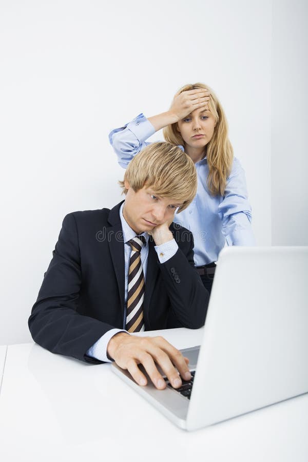 Frustrated Businesspeople Using Laptop at Desk in Office Stock Image ...