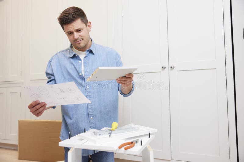 Confused Furniture Assembly Worker While Reading Instructions Stock