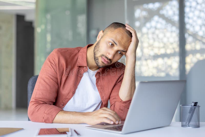 Frustrated Man Facing Challenges while Working on a Laptop in Modern ...
