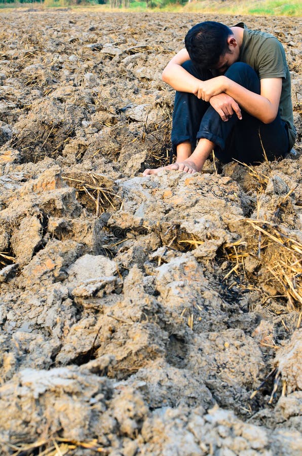 Frustrated and Sad Young Man Sitting in Barren Ground . Stock Image ...