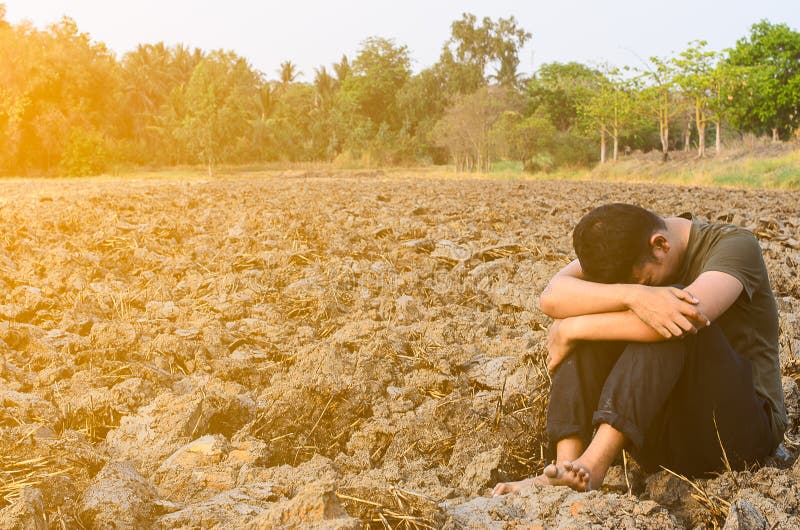 Frustrated and Sad Young Man Sitting in Barren Ground. with Sun Stock ...