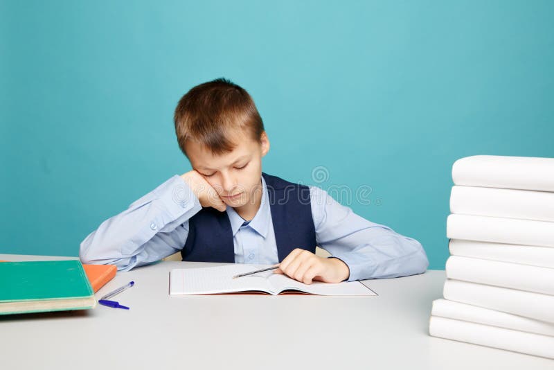 Frustrated Upset Boy at School Sitting at the Desk and Dotng Classwork ...