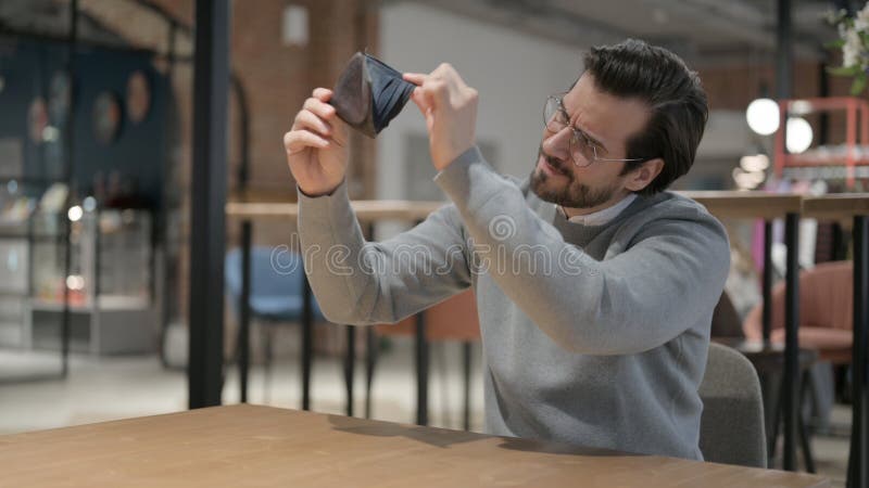 Frustrated Young Man Checking Empty Wallet in Office Stock Photo ...