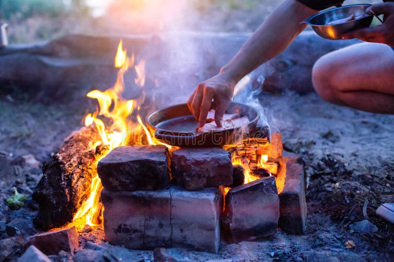 Frying Bacon in a Pan Over a Fire. Cooking Outdoors in the Evening ...