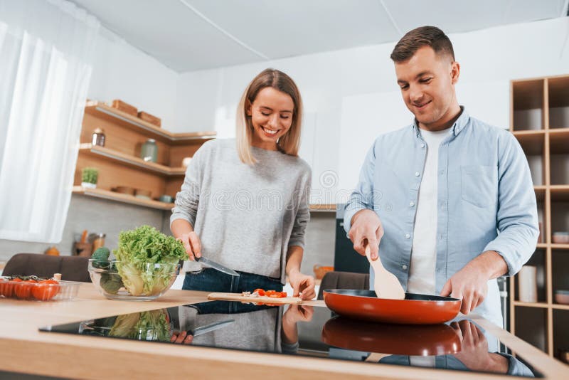 Frying Food in a Pan. Couple Preparing Food at Home on the Modern ...