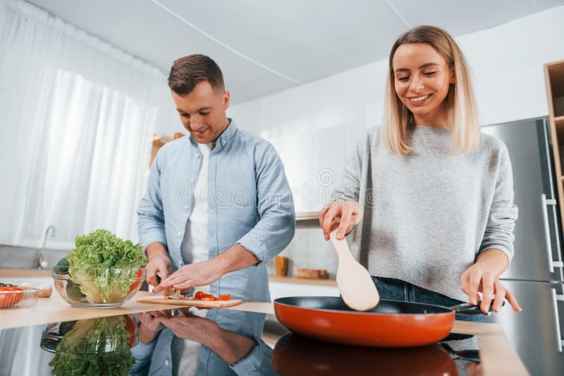 Frying Food in a Pan. Couple Preparing Food at Home on the Modern ...