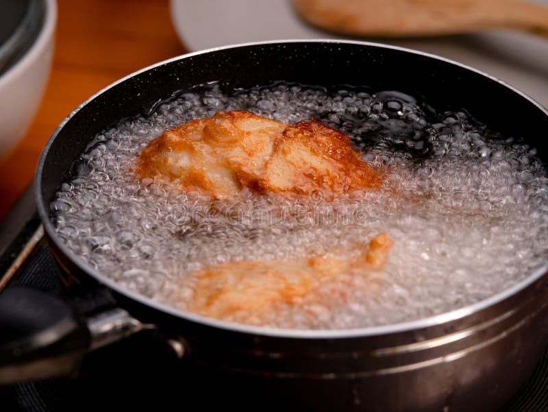 Frying the Marinated Chicken in Hot Oil in a Pan on the Kitchen Stove ...
