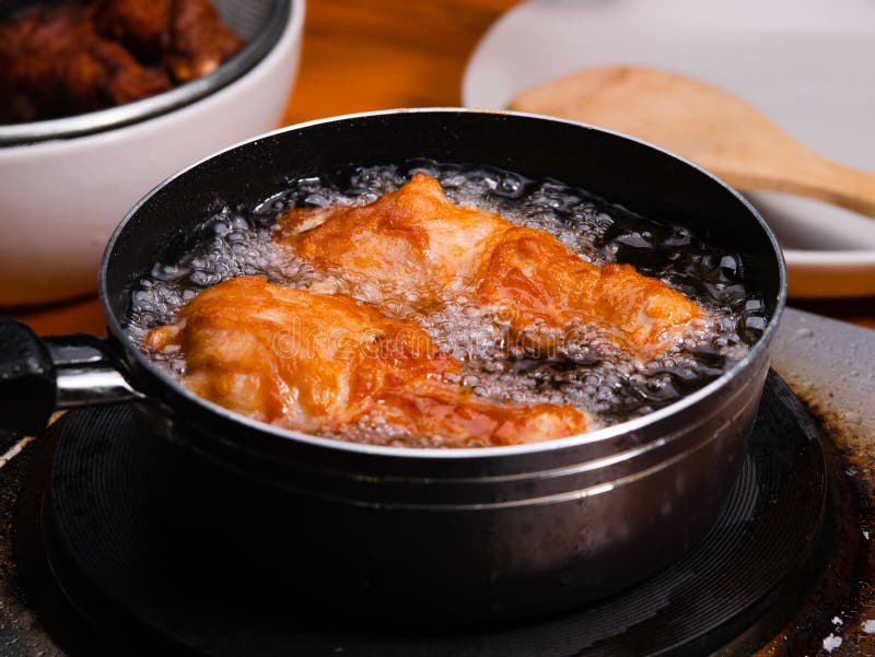 Frying the Marinated Chicken in Hot Oil in a Pan on the Kitchen Stove ...