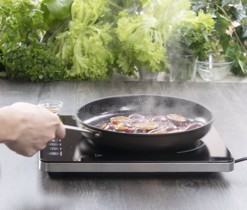 Man`s Hand Cooking Vegetables in Frying Pan on Electric Stove Stock ...