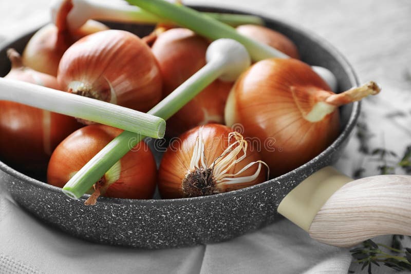Frying Pan with Fresh Onions on Table, Closeup Stock Photo - Image of ...