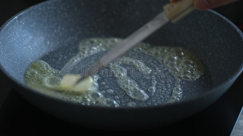 Frying Pan with Melting Butter Being Spreading on it Using a Knife ...