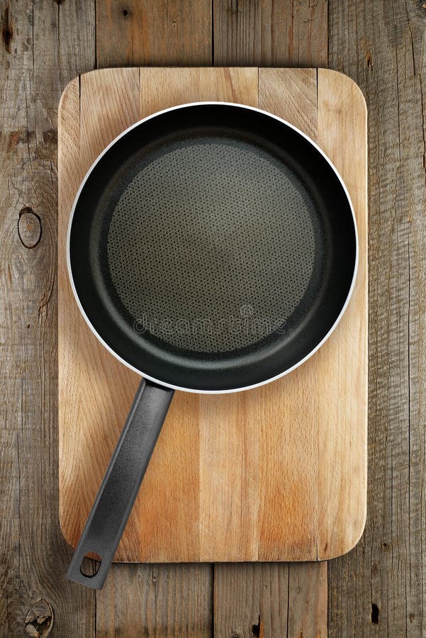 Frying Pan on Wooden Chopping Board Stock Image - Image of board ...