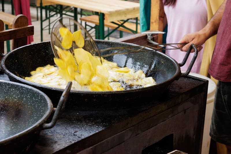 Frying Sliced Potatoes in Oil and Stirring with a Slotted Spoon Stock ...