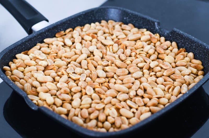 Frying on the Stove in a Black Pan Peanuts Stock Photo - Image of ...