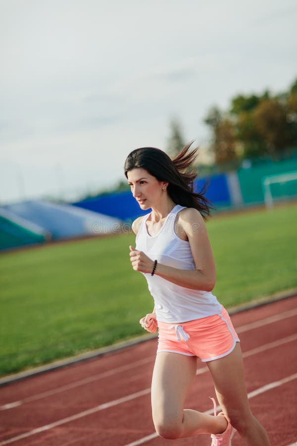 Girl Running Track On Stadium Real Front View Of Young Woman In Pink