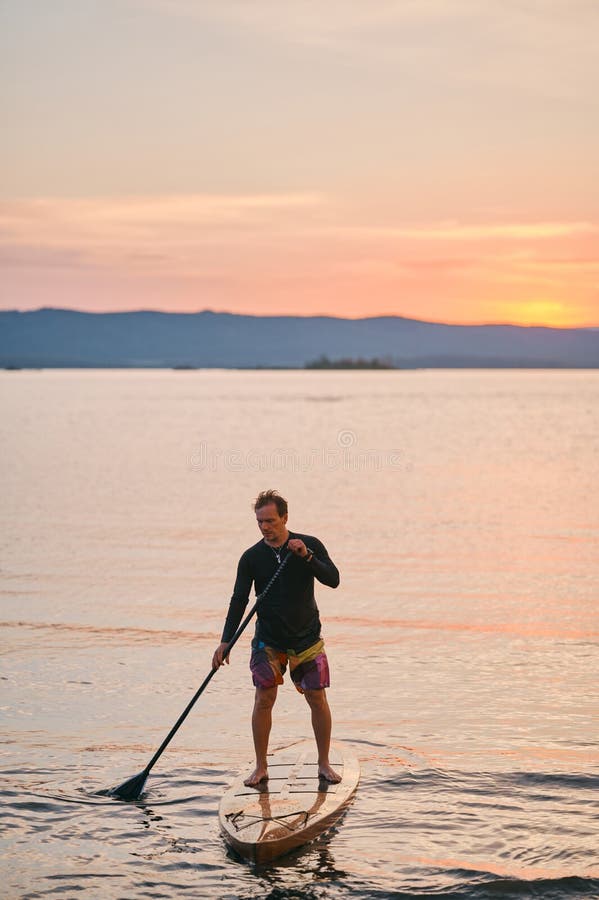 Man Enjoying Paddling the Board on the Lake Stock Photo - Image of ... Man Enjoying Paddling the Board on the Lake Stock Photo - Image of ...