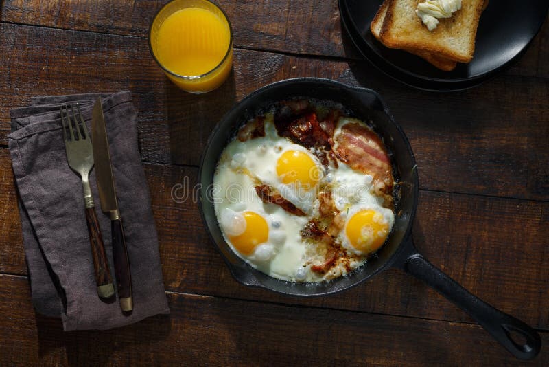 Full Breakfast Table. Fried Eggs with Bacon in Frying Pan Stock Photo ...
