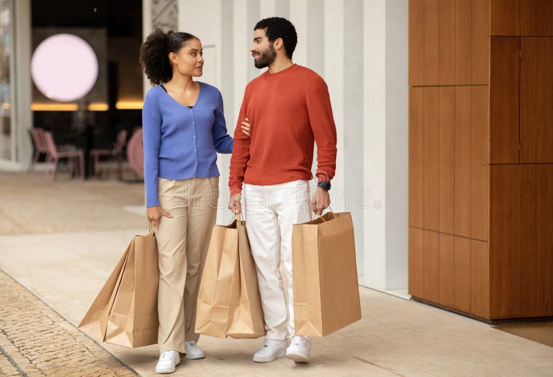 Full Length Of Multiethnic Couple Shopping Standing Holding Bags