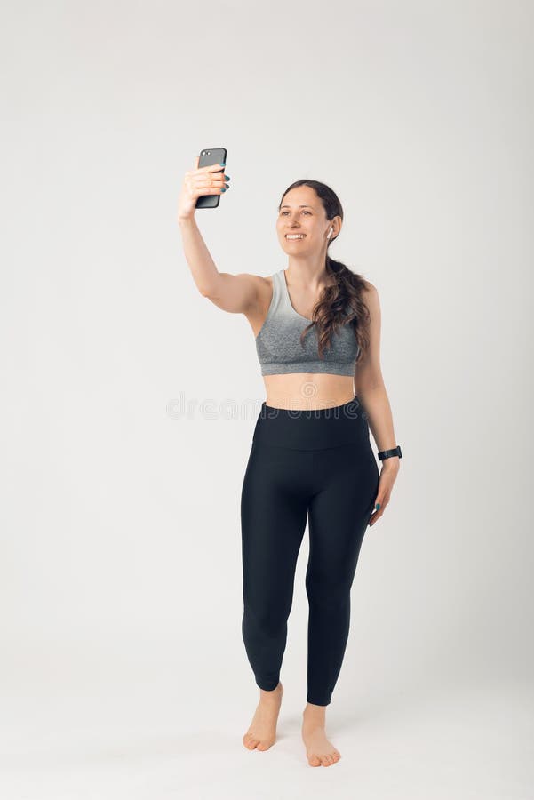 Full Length Photo Of Sport Woman Taking Selfie Over White Wall Stock