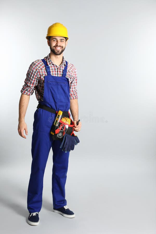 Full Length Portrait of Construction Worker with Tool Belt on Light ...