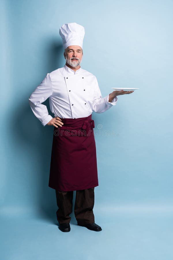 Full Length of a Professional Chef Holding an Empty Plate on Light Blue ...