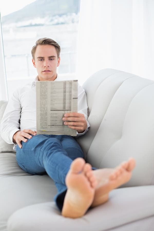 Full Length of a Relaxed Man Reading Newspaper on Sofa Stock Photo ...