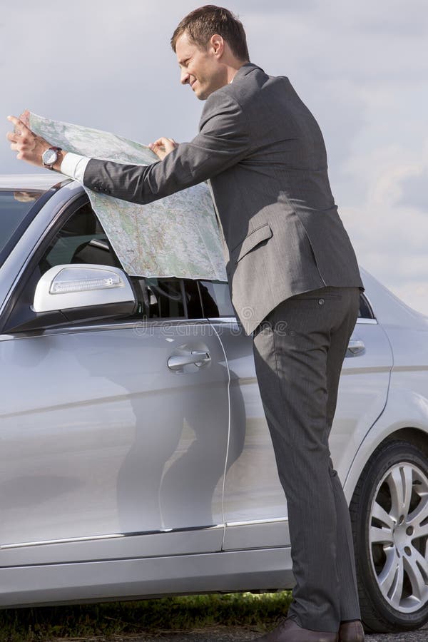 Full Length Side View of Young Businessman Reading Map by Car at ...