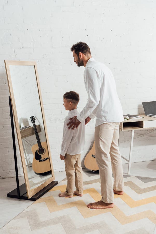 Length View of Barefoot Father and Son Standing Near Mirror Stock Photo ...