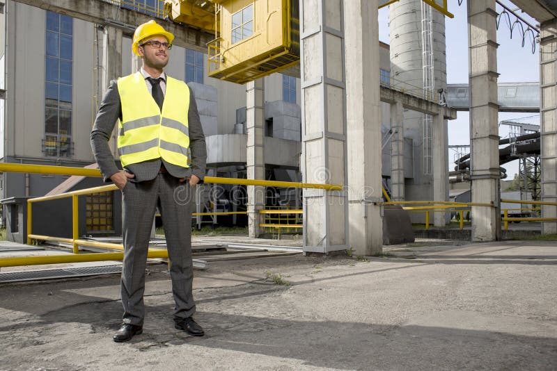 Full Length of Young Male Engineer with Hands in Pockets Standing ...