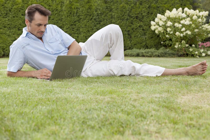 Full Length of Young Man Working on Laptop in Park Stock Photo - Image ...