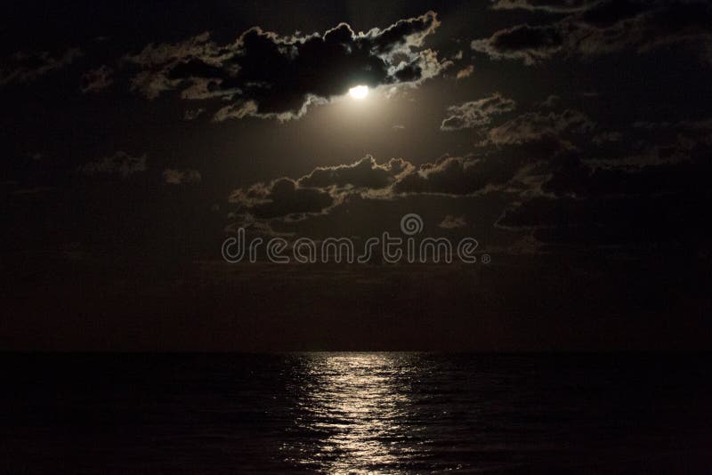 Full Moon in a Cloudy Night Sky Reflecting Moonlight on Sea Stock Image ...