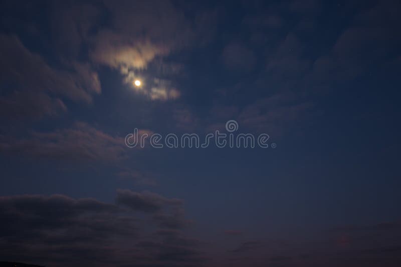 Full Moon in the Middle of Warm Coloured Clouds at Dusk Stock Photo ...