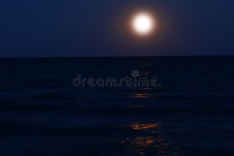 Full Moon Rising from the Sea with Reddish Effect that is Reflec Stock ...