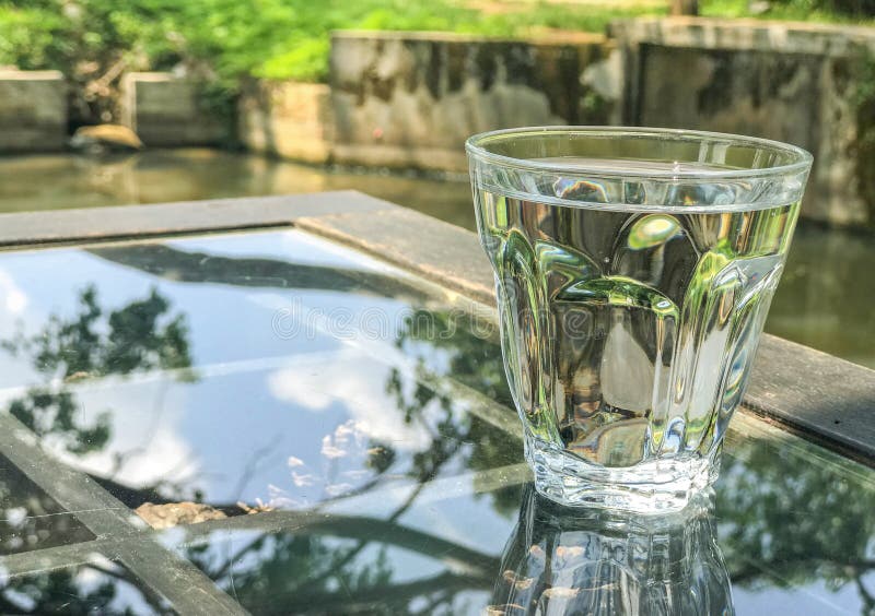 Full Pure Water Glass on Table in the Green Garden. Stock Photo - Image ...