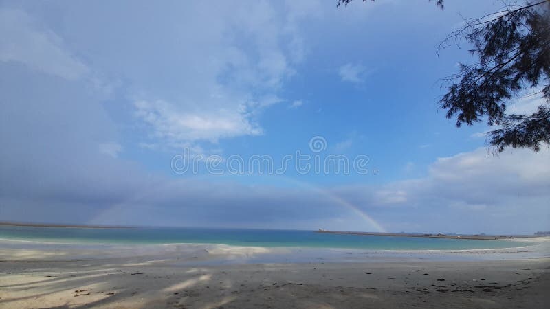 Full Rainbow in the Beach, Blue Sky, and Little Bit Cloudy Stock Photo ...