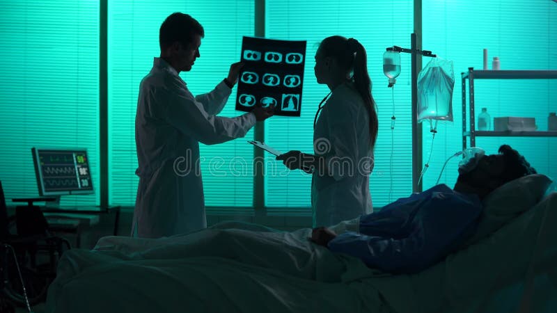 Full-sized Silhouette Video of Two Doctors Standing Next To a Patient ...