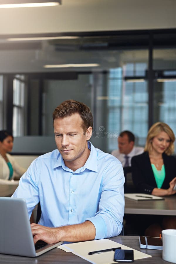 Fully Engaged in His Work Tasks. a Businessman Using a Laptop at His ...