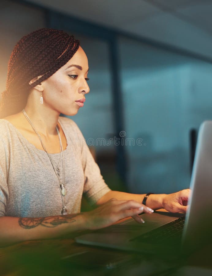 Fully Focused on the Task at Hand. a Young Woman Using Her Laptop while ...
