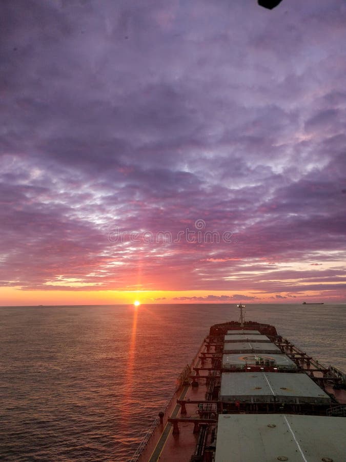 A Fully Loaded Bulk Carrier Ship Running Onto the Sunset Stock Image ...