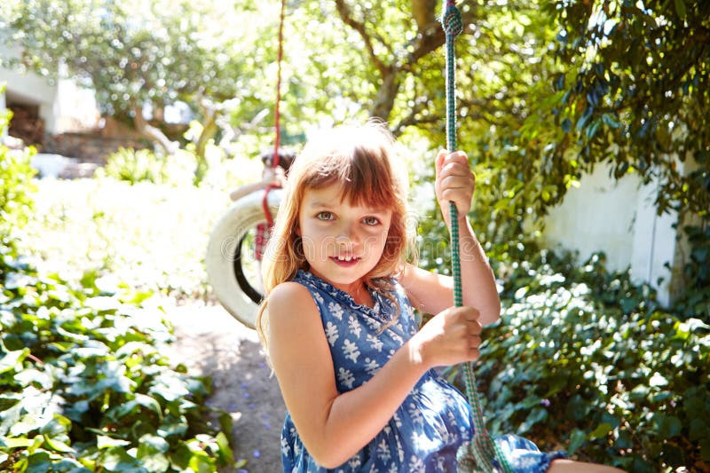 Fun in the Backyard. a Young Girl Swinging in the Yard. Stock Image ...