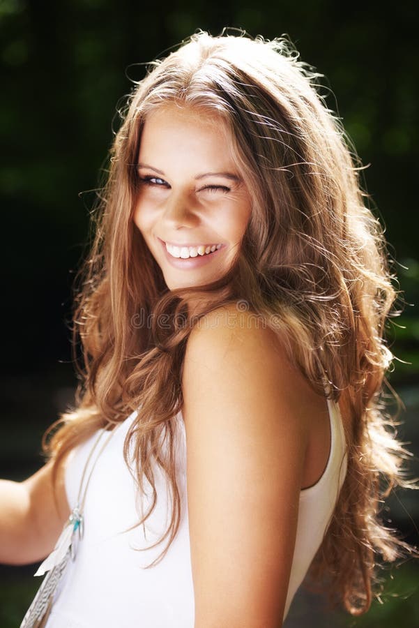 Fun And Flirty Portrait Of A Beautiful Young Woman Winking At You In A