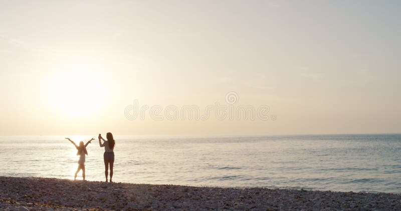 Fun Free And Wild Friends Jumping And Fooling Around On A Beach
