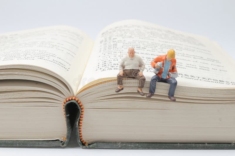 A Fun of Mini People:figure Sitting on Book Editorial Photography ...