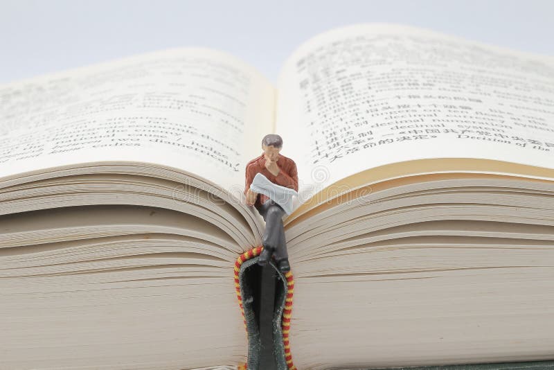 A Fun of Mini People:figure Sitting on Book Stock Photo - Image of ...